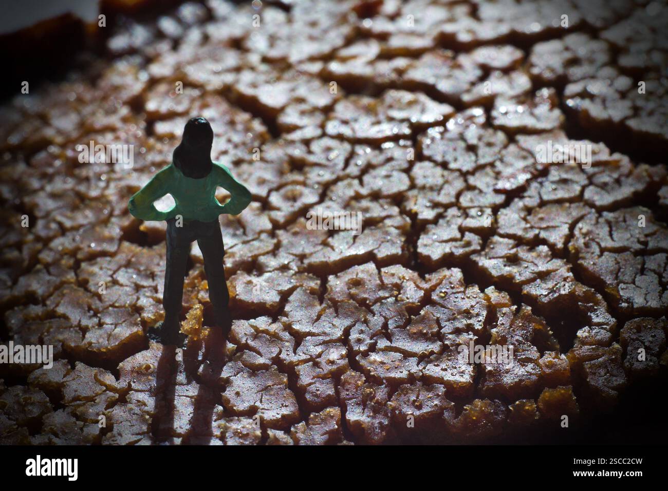 Top view of a miniature woman over dry earth, concept of global warming ...