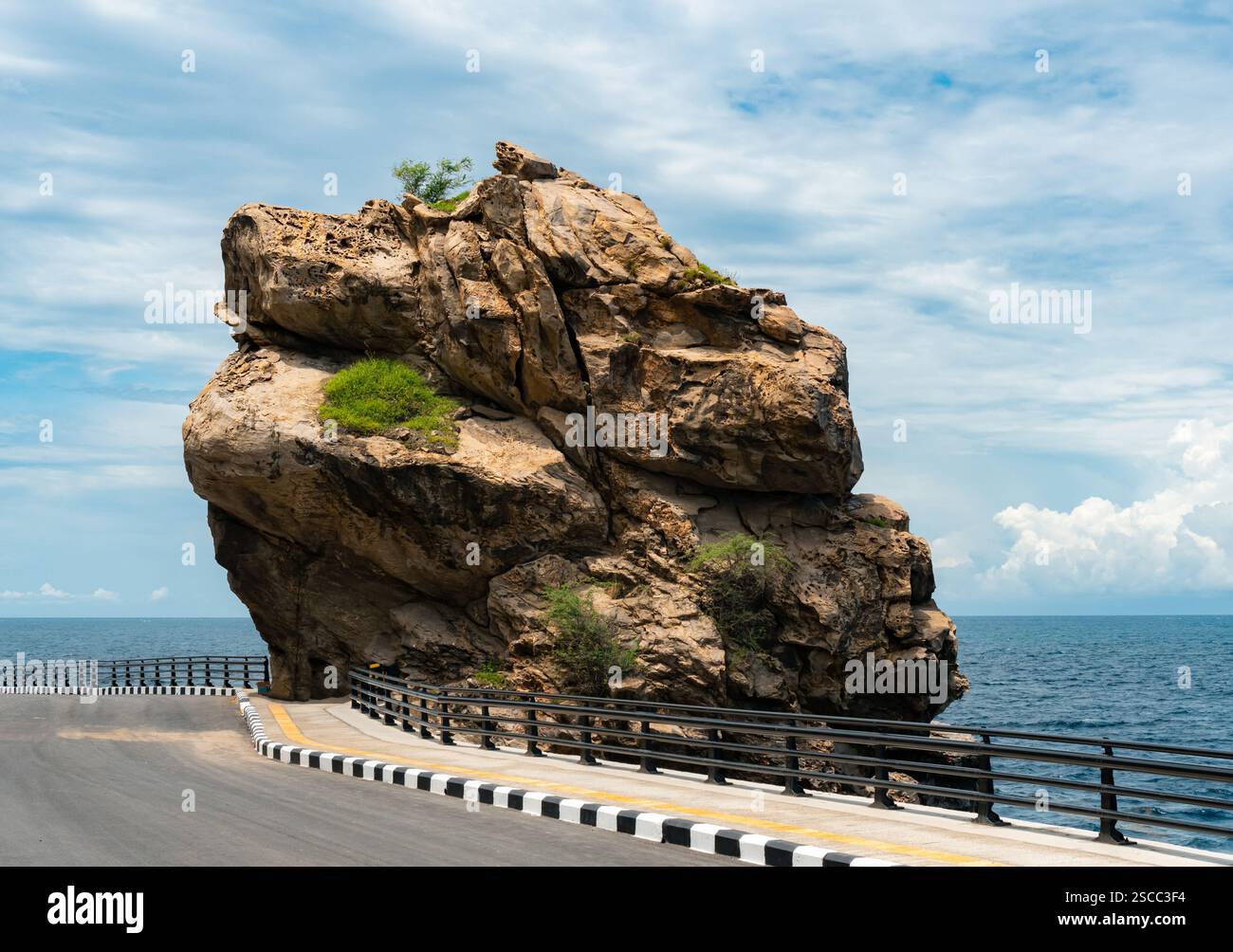 Giant stone lay next to coastal road in the ocean Stock Photo - Alamy
