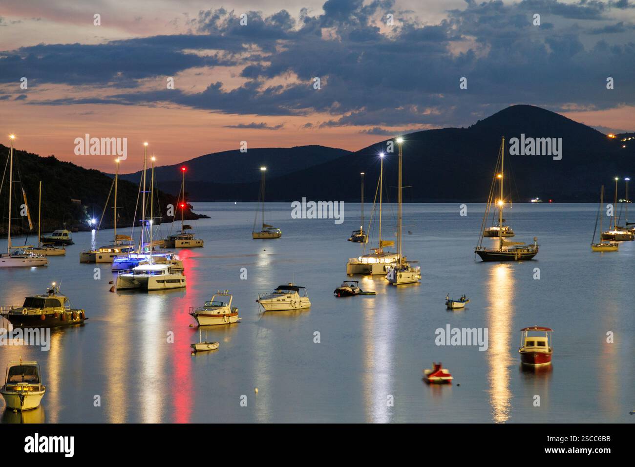 Aerial night view of little fisher village bay with yachts and ...