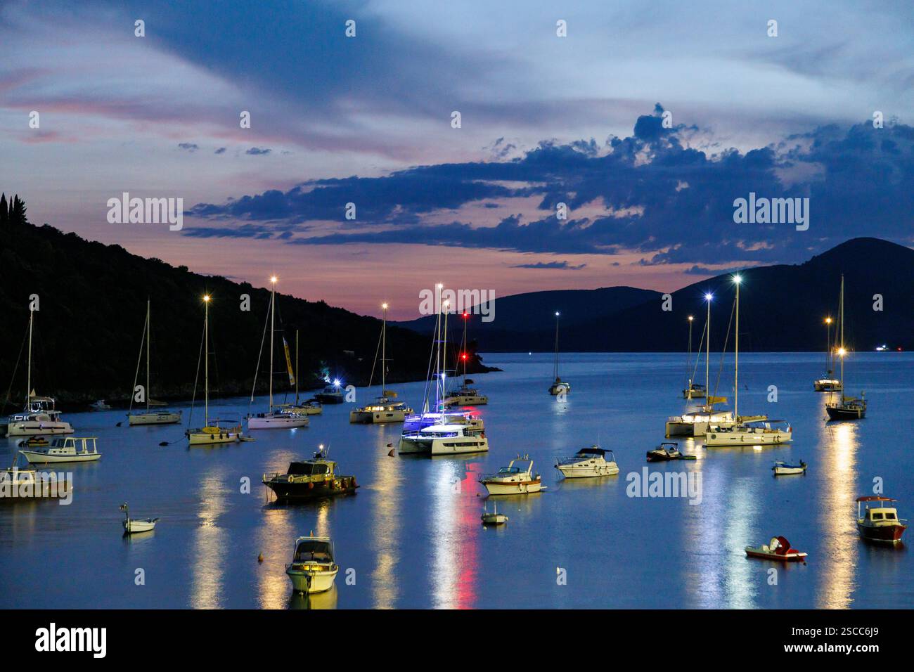 Aerial night view of little fisher village bay with yachts and ...
