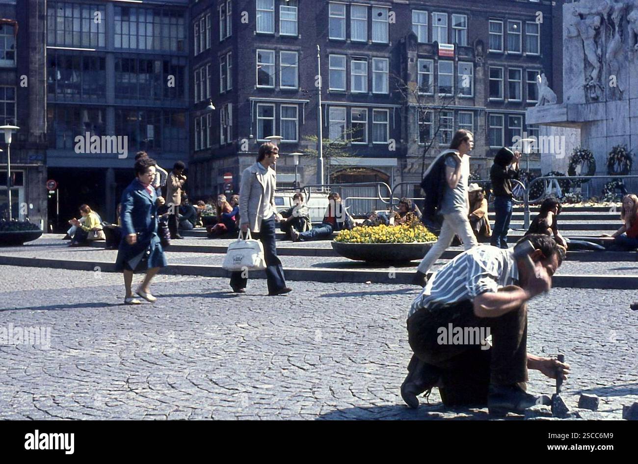 Dam Square in Amsterdam. Picture shows a mason, passersby and youths on ...