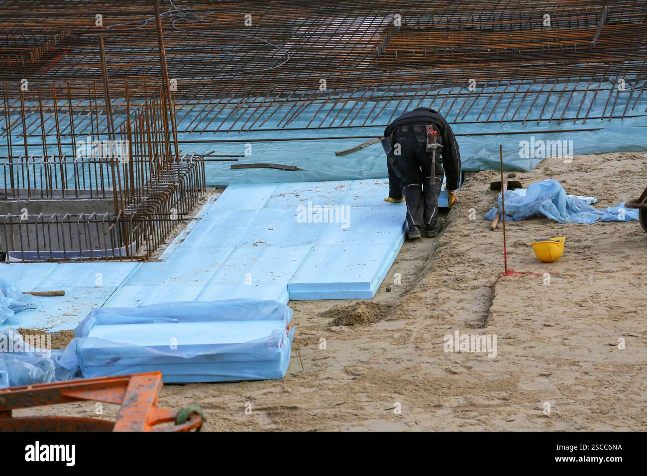 Worker laying floor insulation at construction site Stock Photo - Alamy