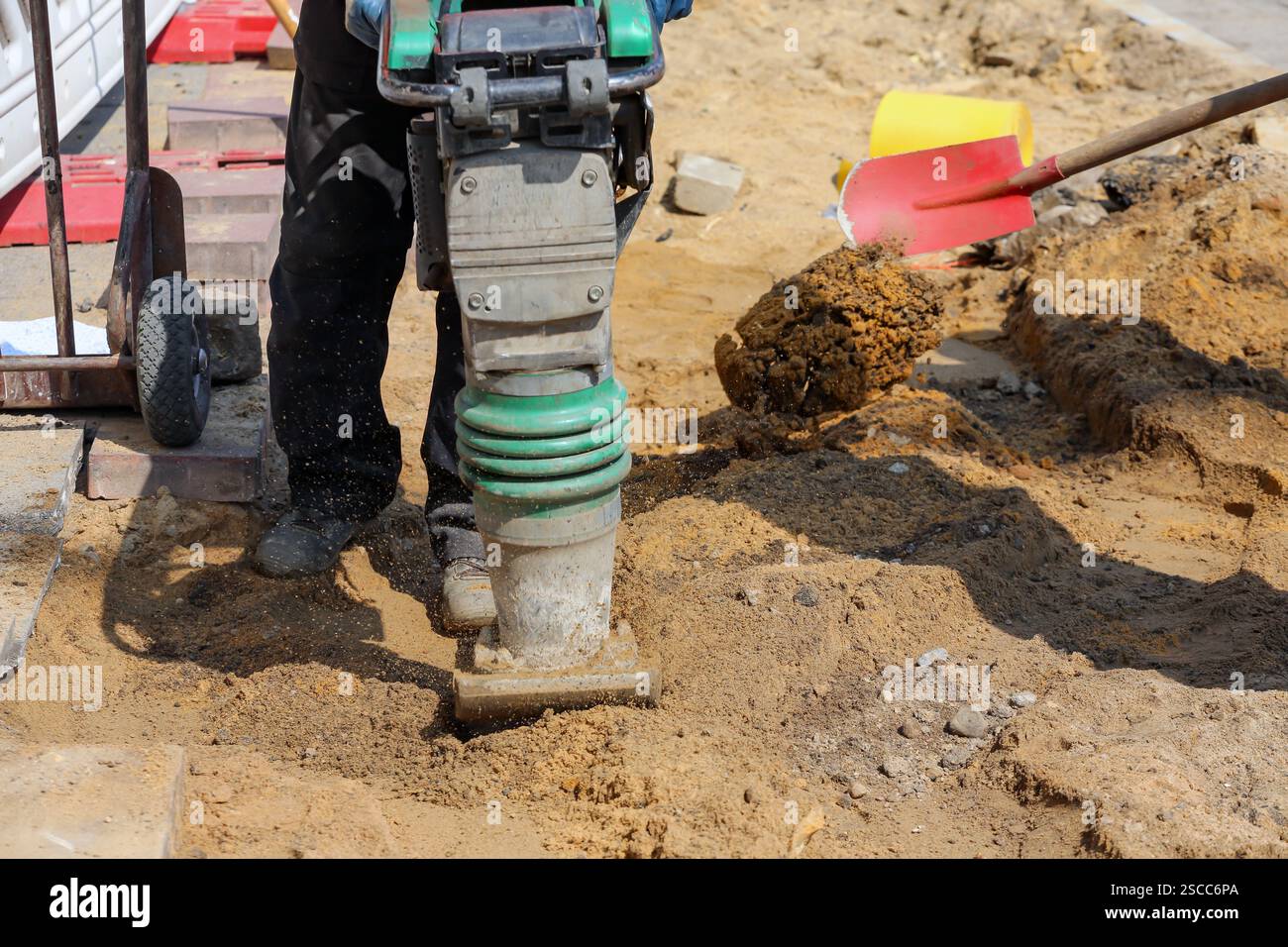 man with vibratory rammer compacting soil Stock Photo - Alamy