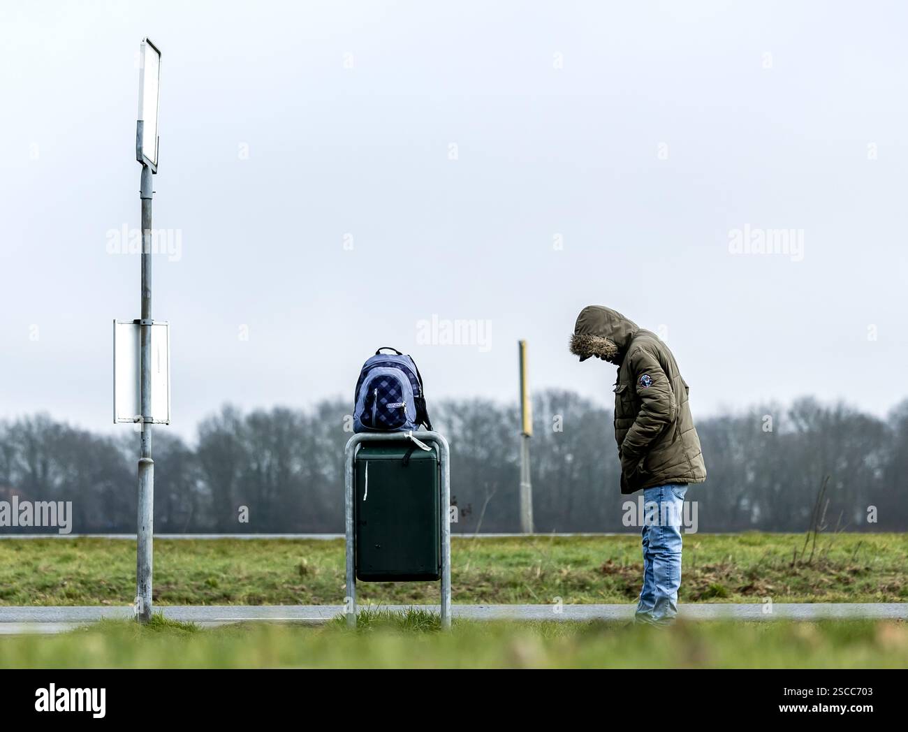 TER APEL - A resident of the AZC Ter Apel waits at a bus stop prior to ...