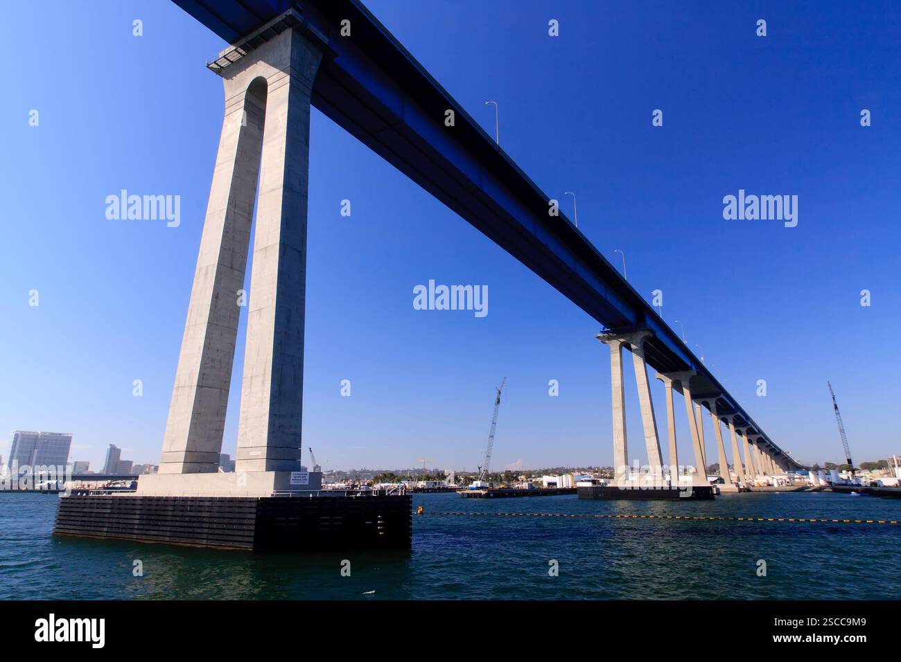Large bridge spans a body of water, with a blue sky above. The bridge ...
