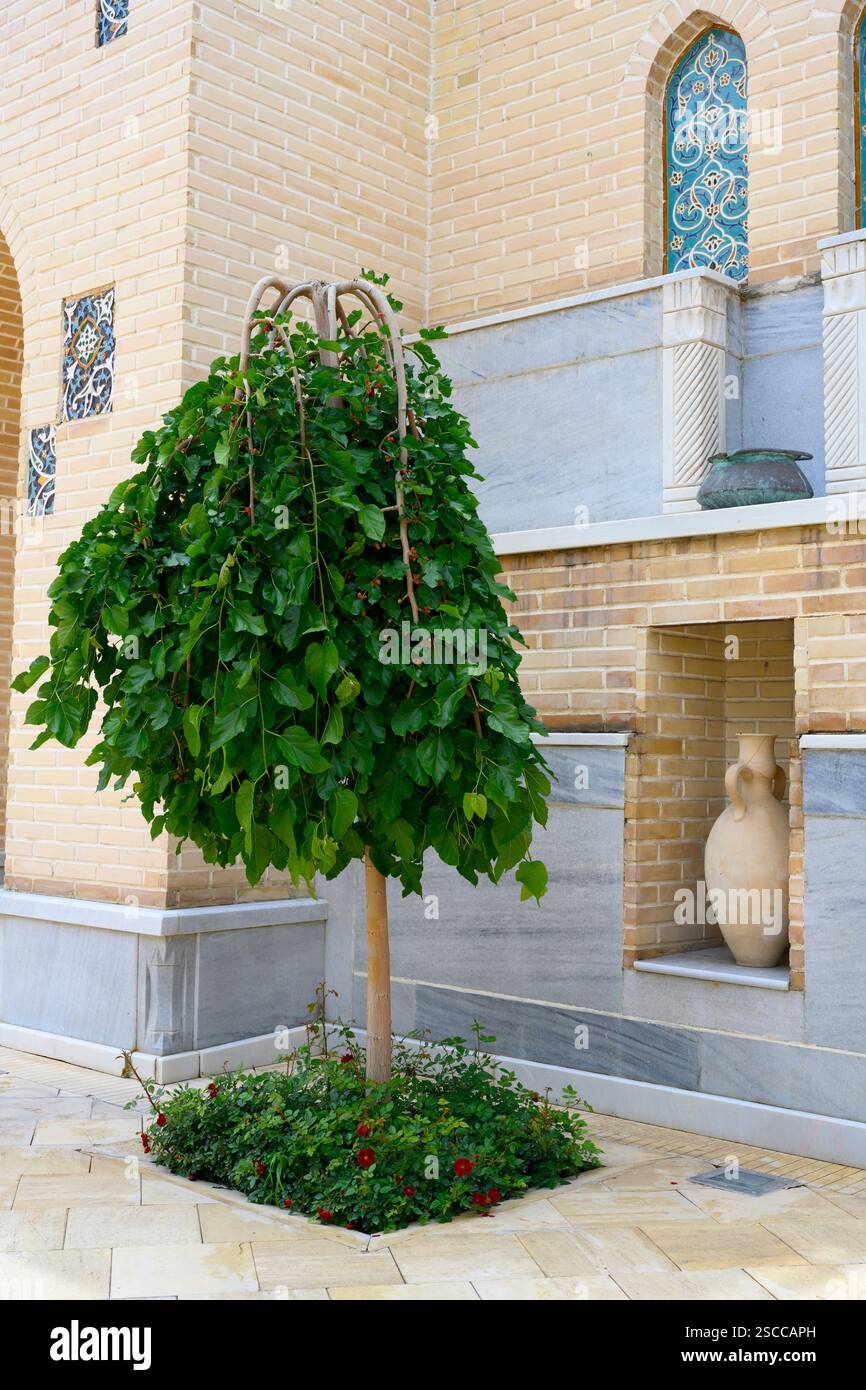 Tree and brick wall in a traditional Asian style with mosaics and ...