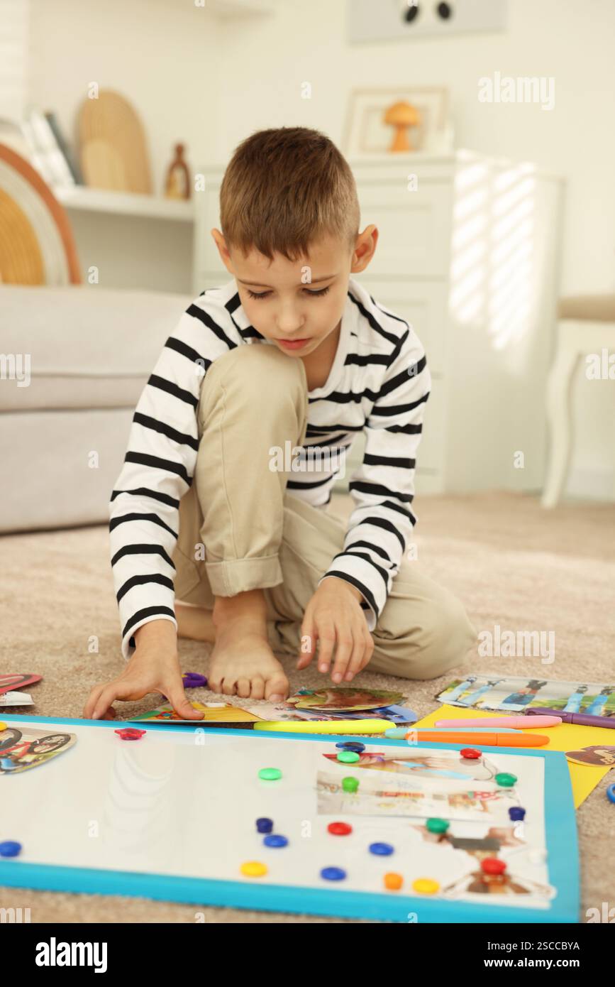 Little boy creating vision board with different pictures and other ...