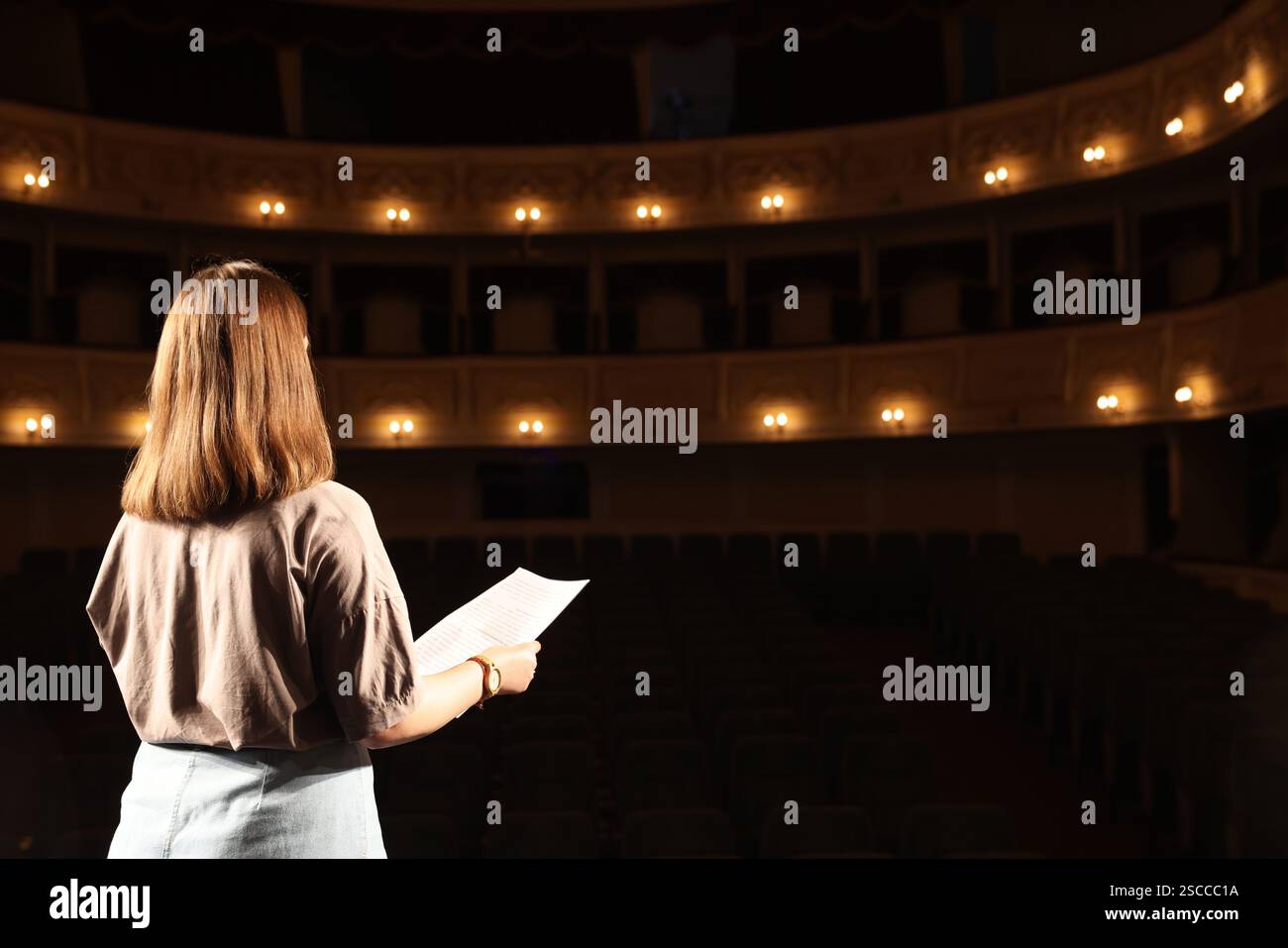 Professional actress rehearsing on stage in theatre, back view Stock ...