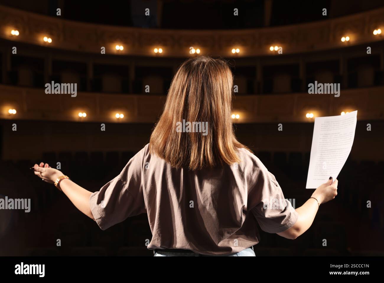Professional actress rehearsing on stage in theatre, back view Stock ...