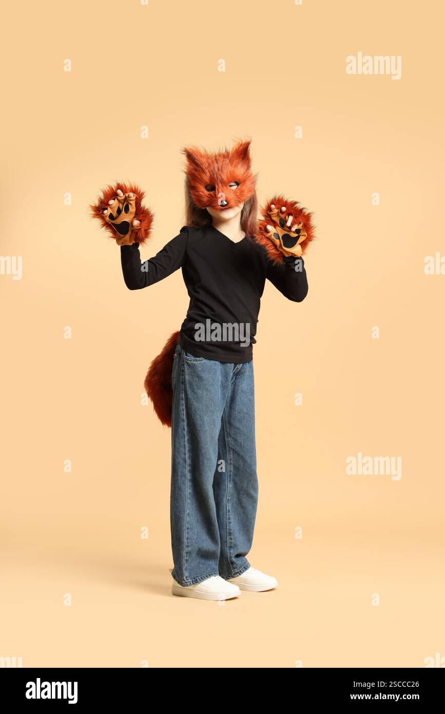 Quadrobics. Girl wearing fox mask, tail and gloves on beige background ...