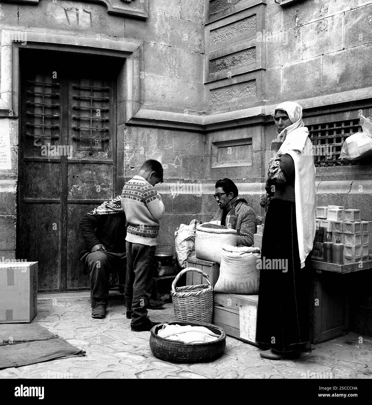 Two men selling soap in the old city of Jerusalem. A woman looks into ...