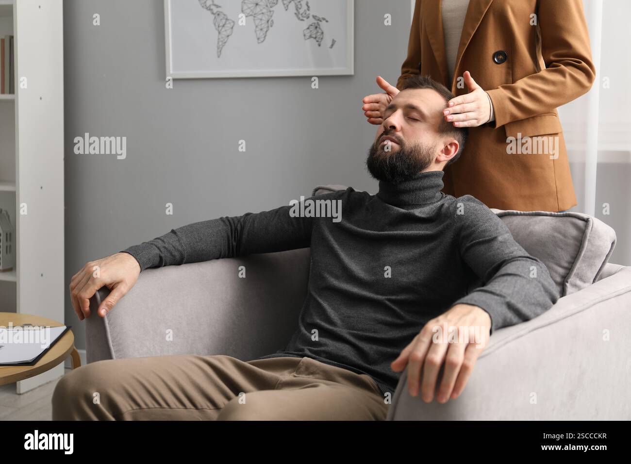 Psychologist working with patient during hypnosis session indoors ...