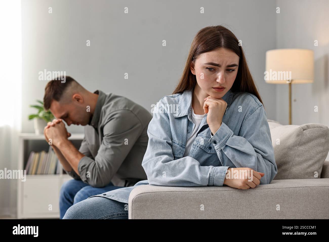 Offended couple ignoring each other at home Stock Photo - Alamy