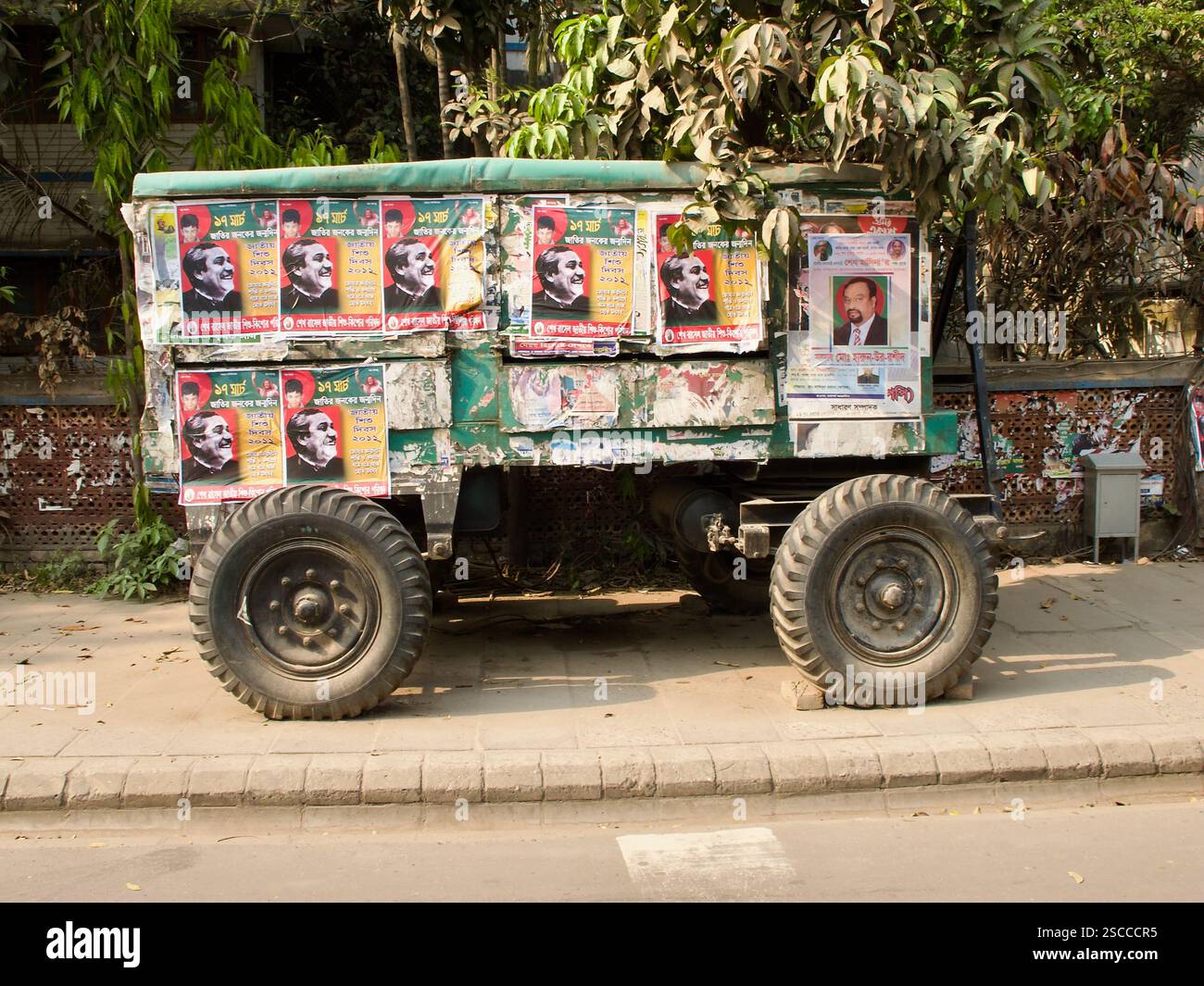 A weathered cart in Dhaka covered in political posters featuring Sheikh ...