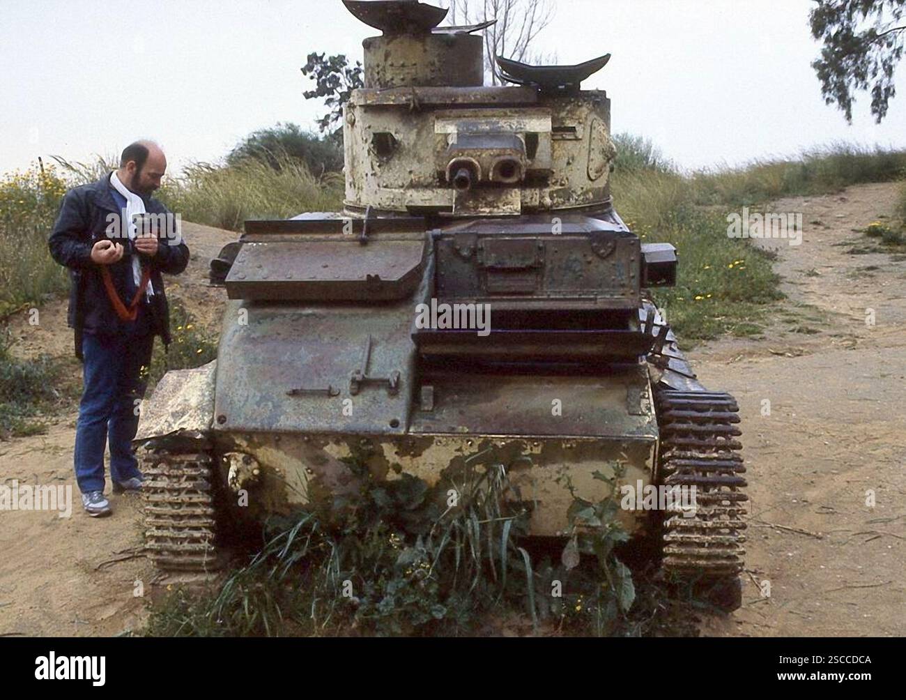 Man with camera and an old tank in Mordechai Stock Photo - Alamy