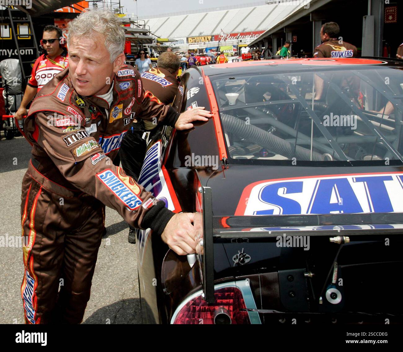FILE - NASCAR driver Ricky Rudd pushes his car with members of his crew ...