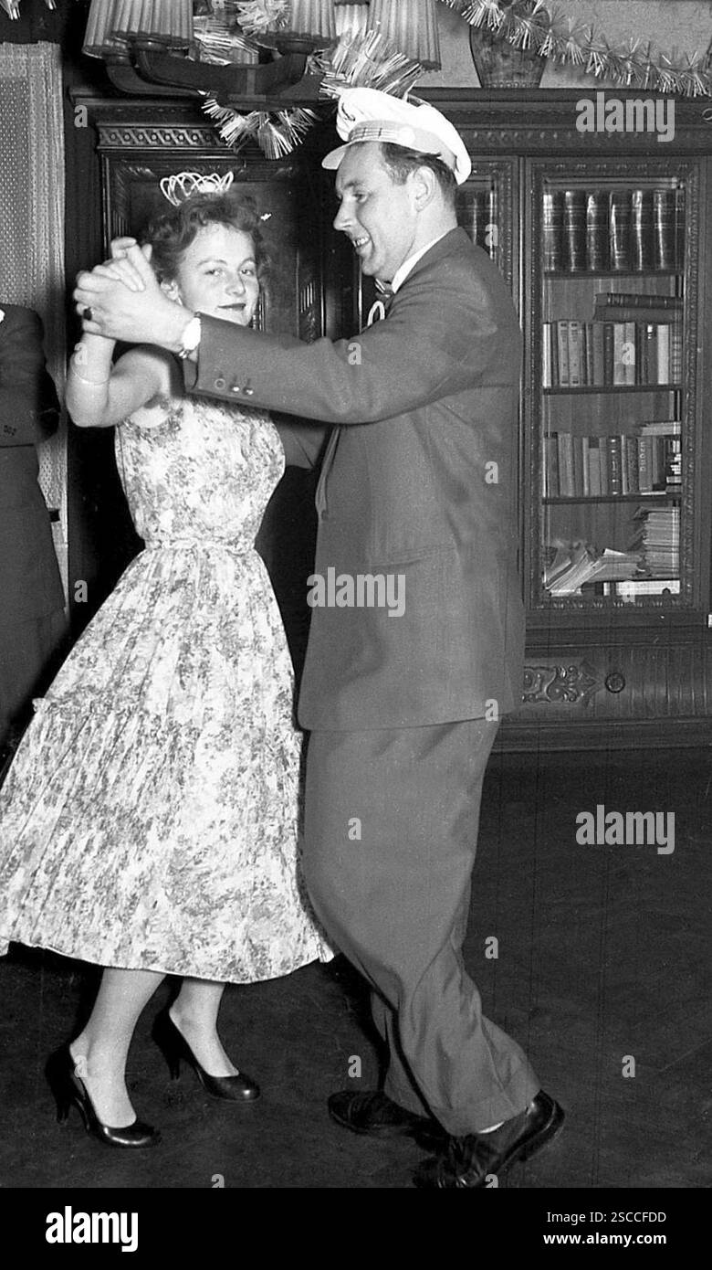 A costumed couple is dancing in front of the bookcase at their home ...