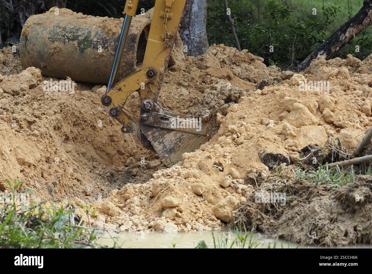 Excavator digging ground for pipe rainwater drainage in countryside ...