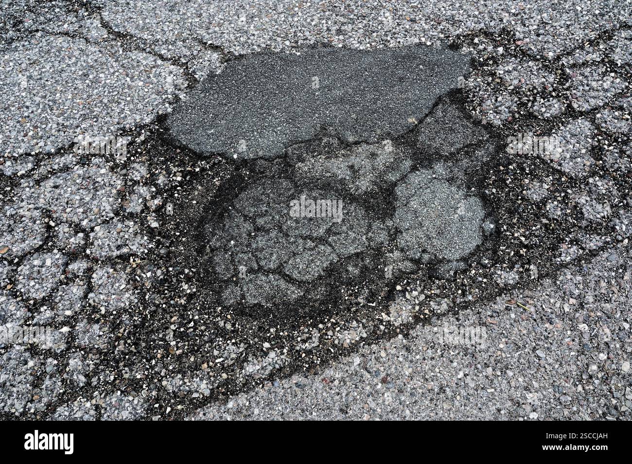 Vorsicht Straßenschäden . Risse in der Straßenoberfläche deuten auf ...