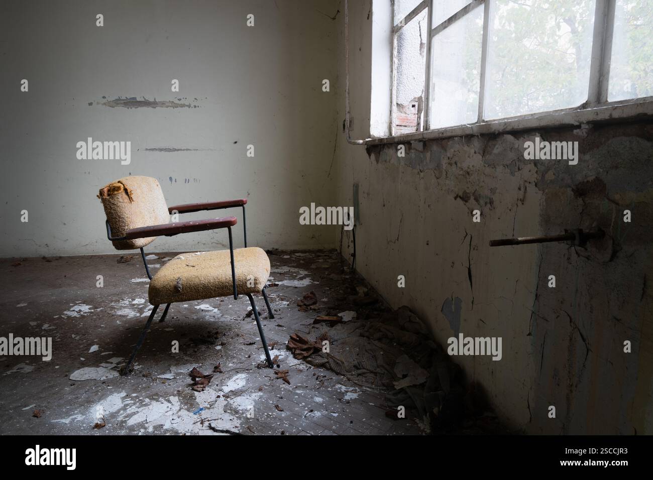 Dirty chair in abandoned room next to window in soft daylight, urban ...
