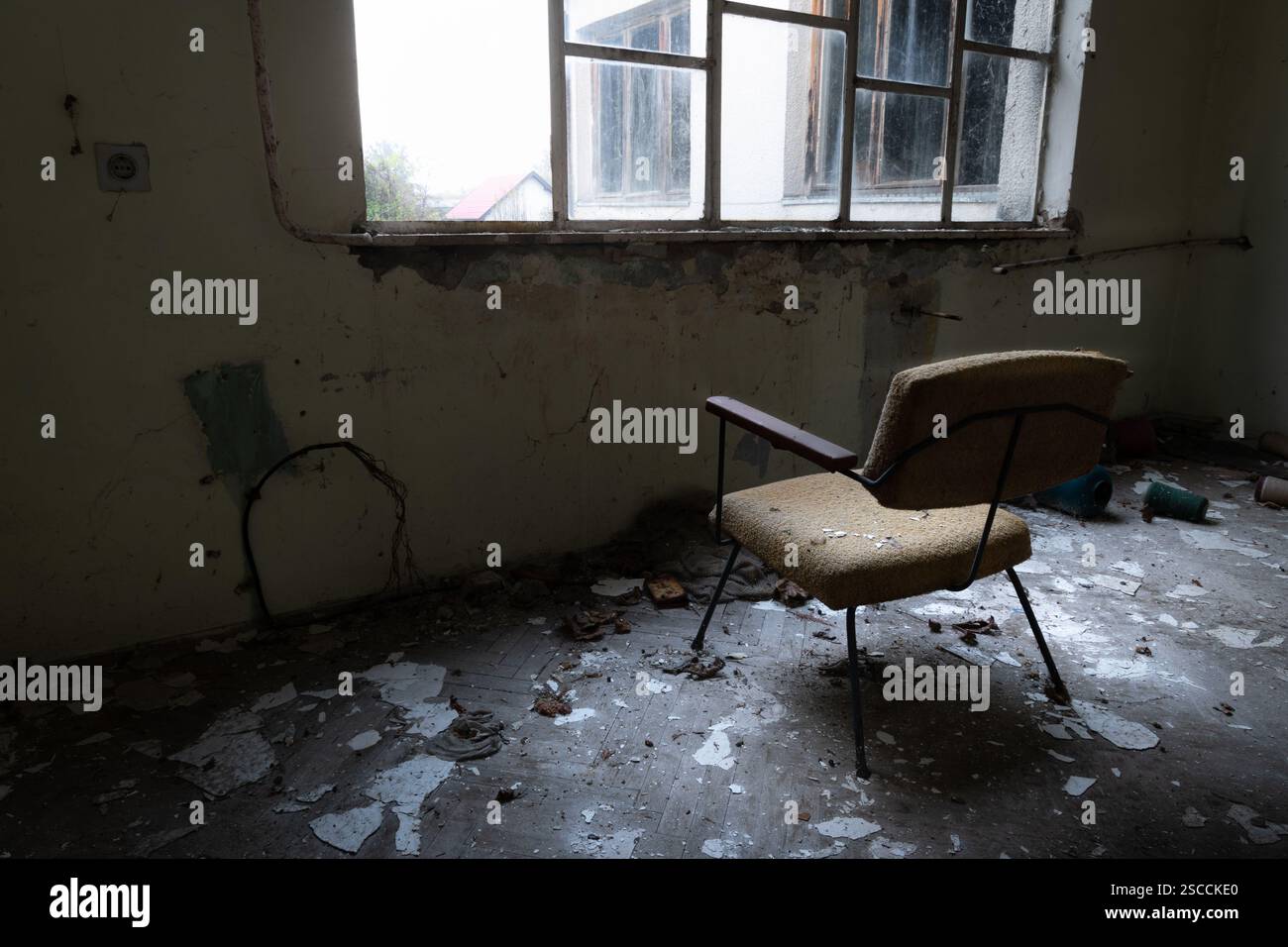 Dirty chair in abandoned room next to window in soft daylight, urban ...