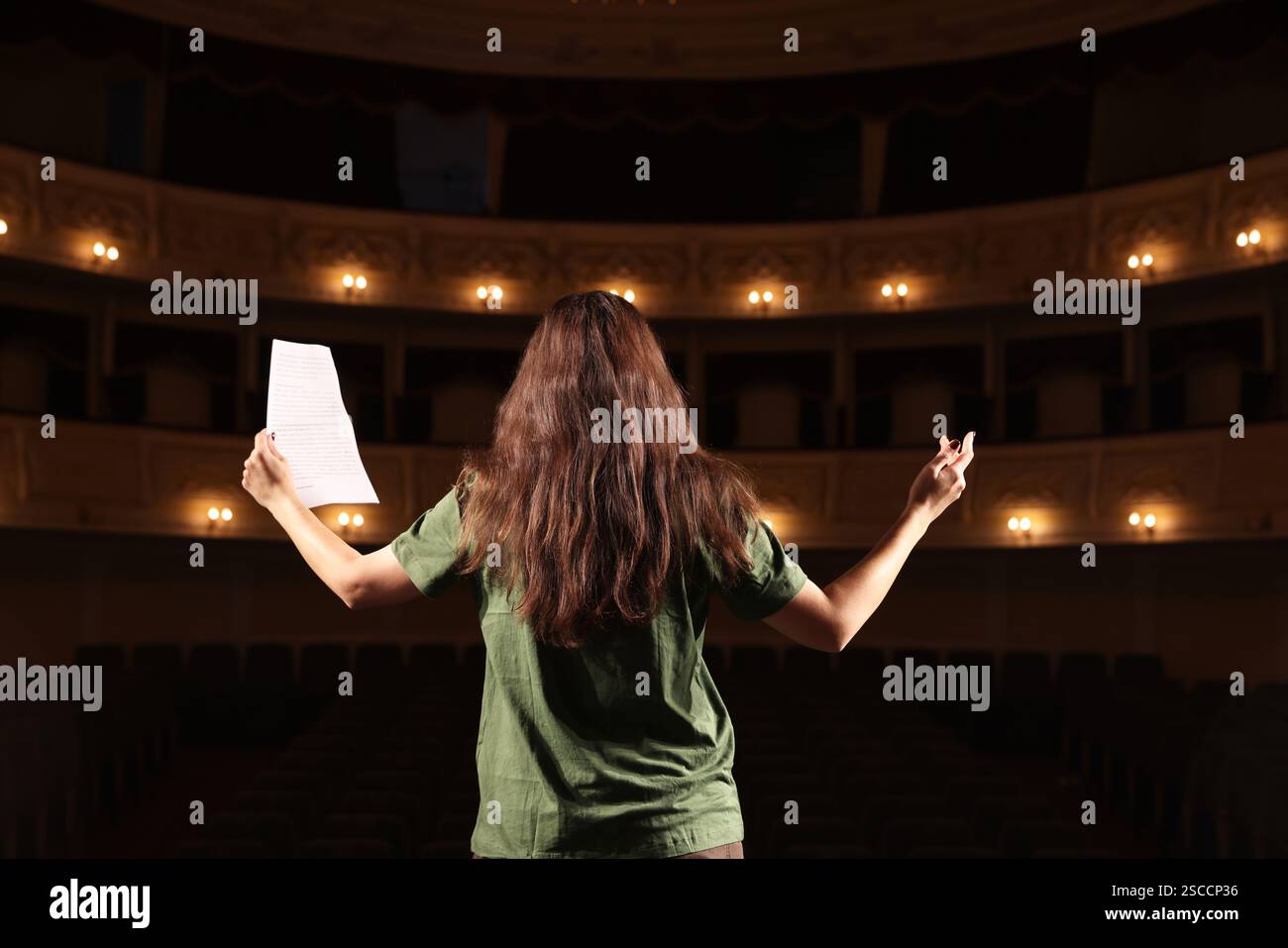 Professional actress rehearsing on stage in theatre, back view Stock ...