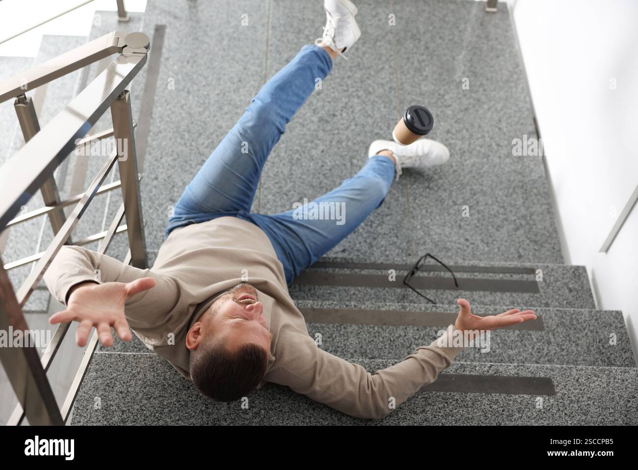 Injured man on stairs in building after fall, above view. Dangerous ...