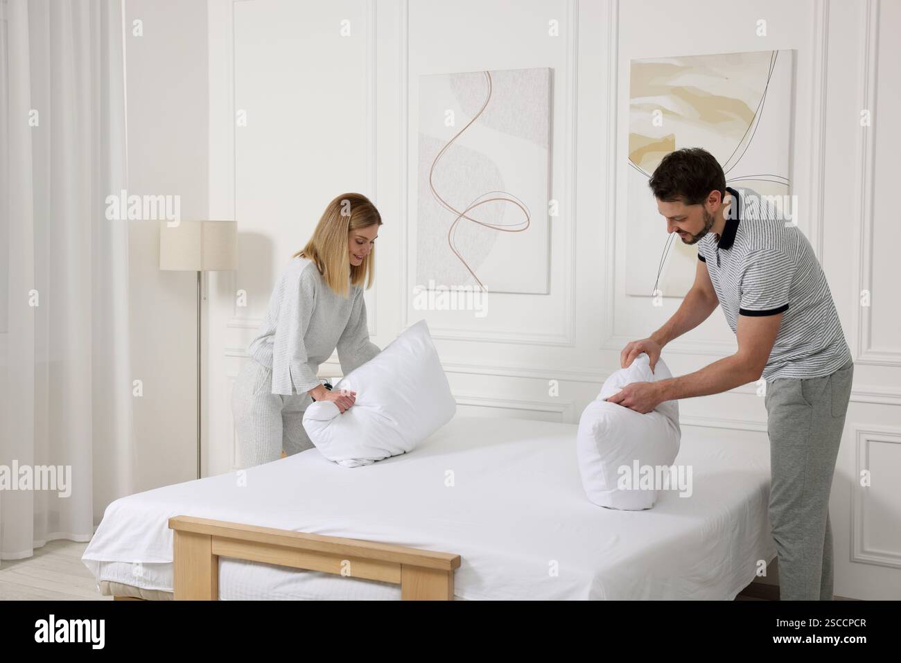 Couple changing bed linens at home. Domestic chores Stock Photo - Alamy