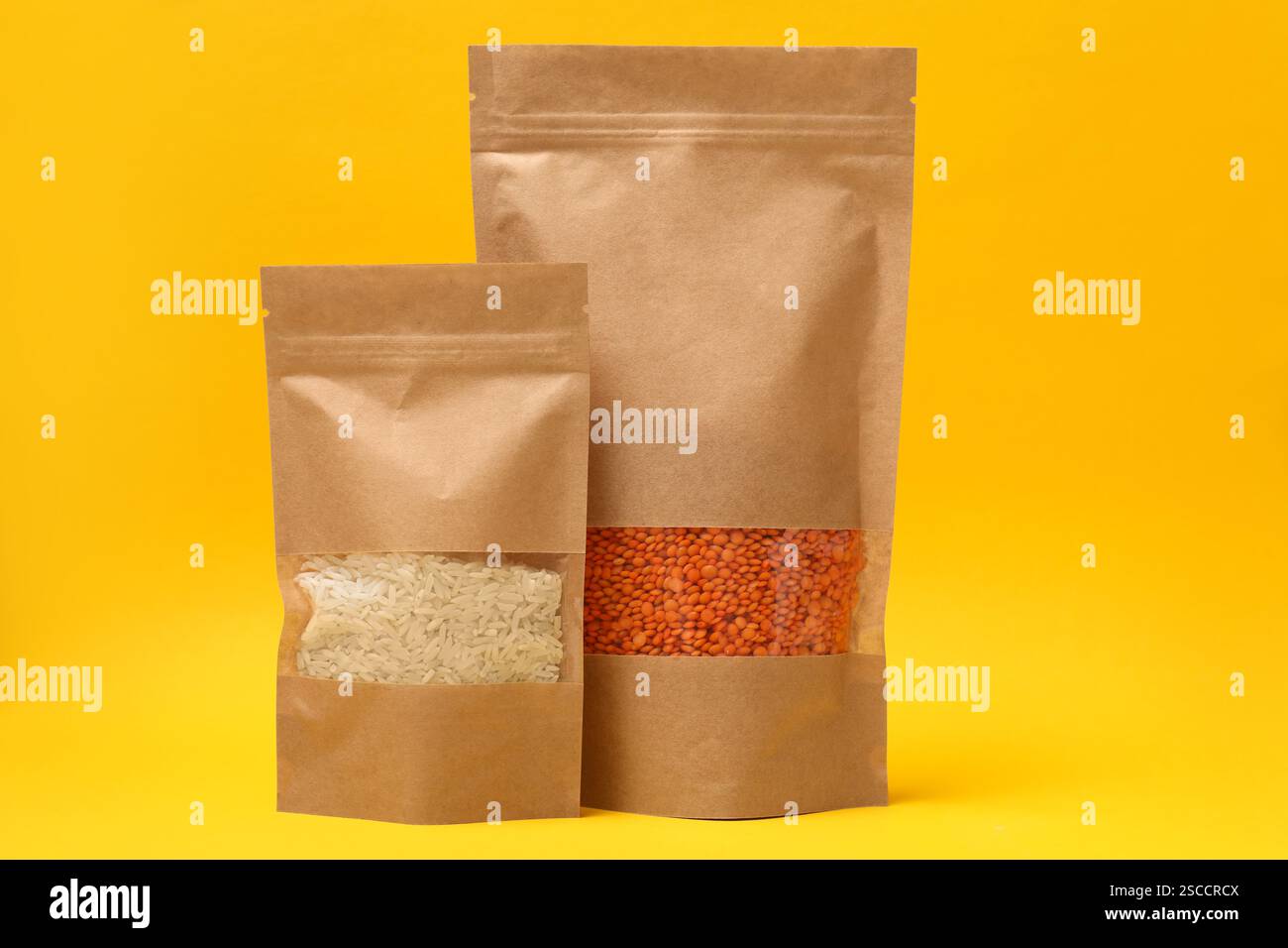 Paper pouch bags with lentil and rice on yellow background Stock Photo ...
