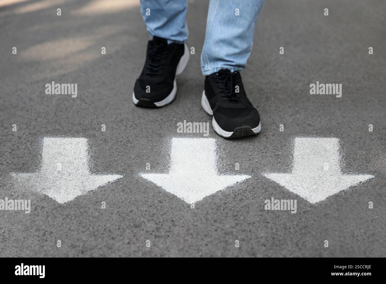 Man walking on asphalt road with white arrows, closeup. Concepts of ...