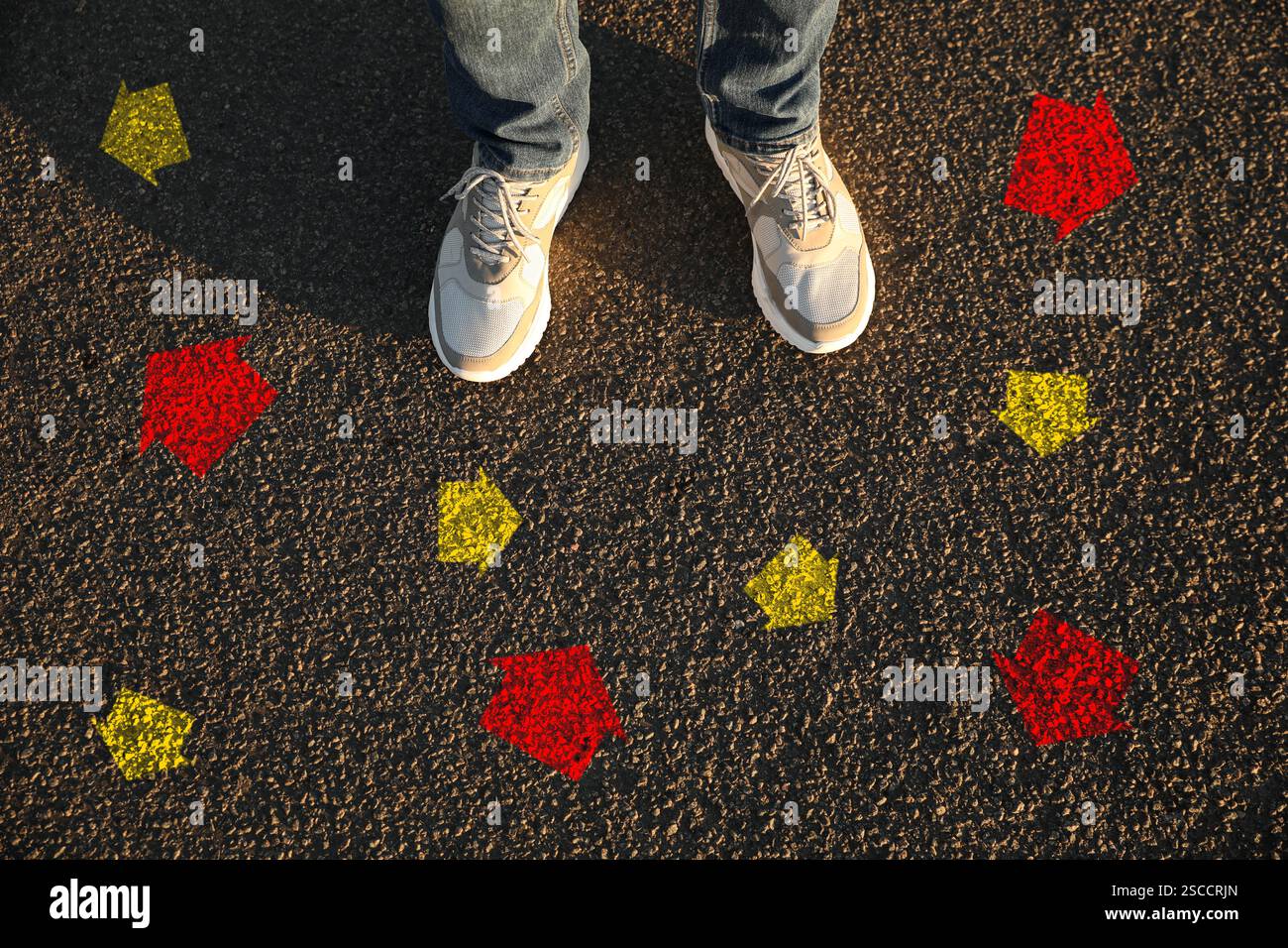 Man standing near red and yellow arrows pointing in different ...