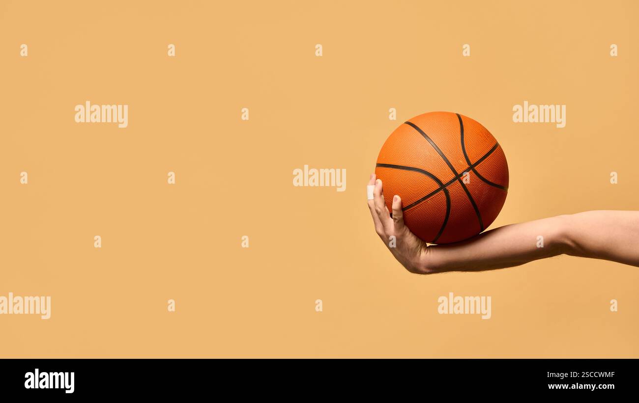 Arm extended outward, gripping basketball firmly, demonstrating ...