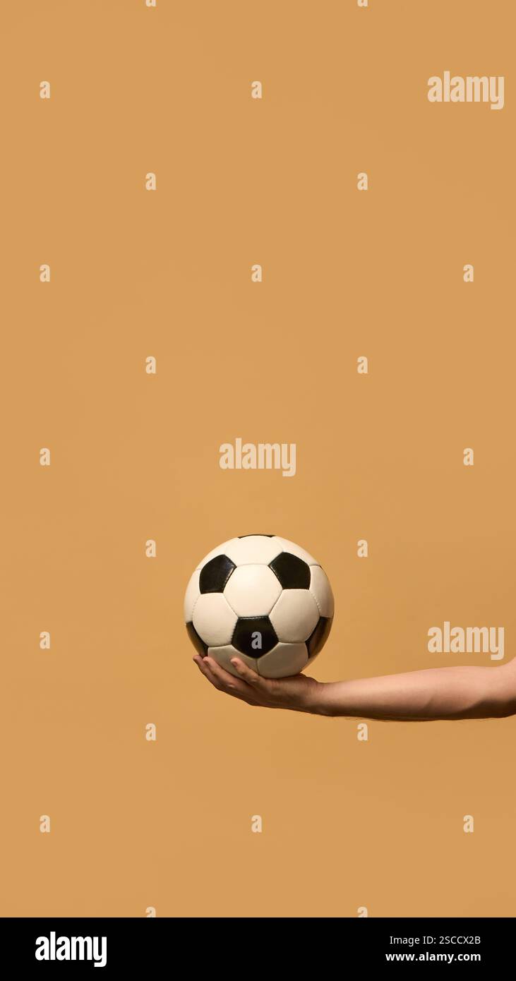 Vertical image of hand holding soccer ball ready to throw it and start ...