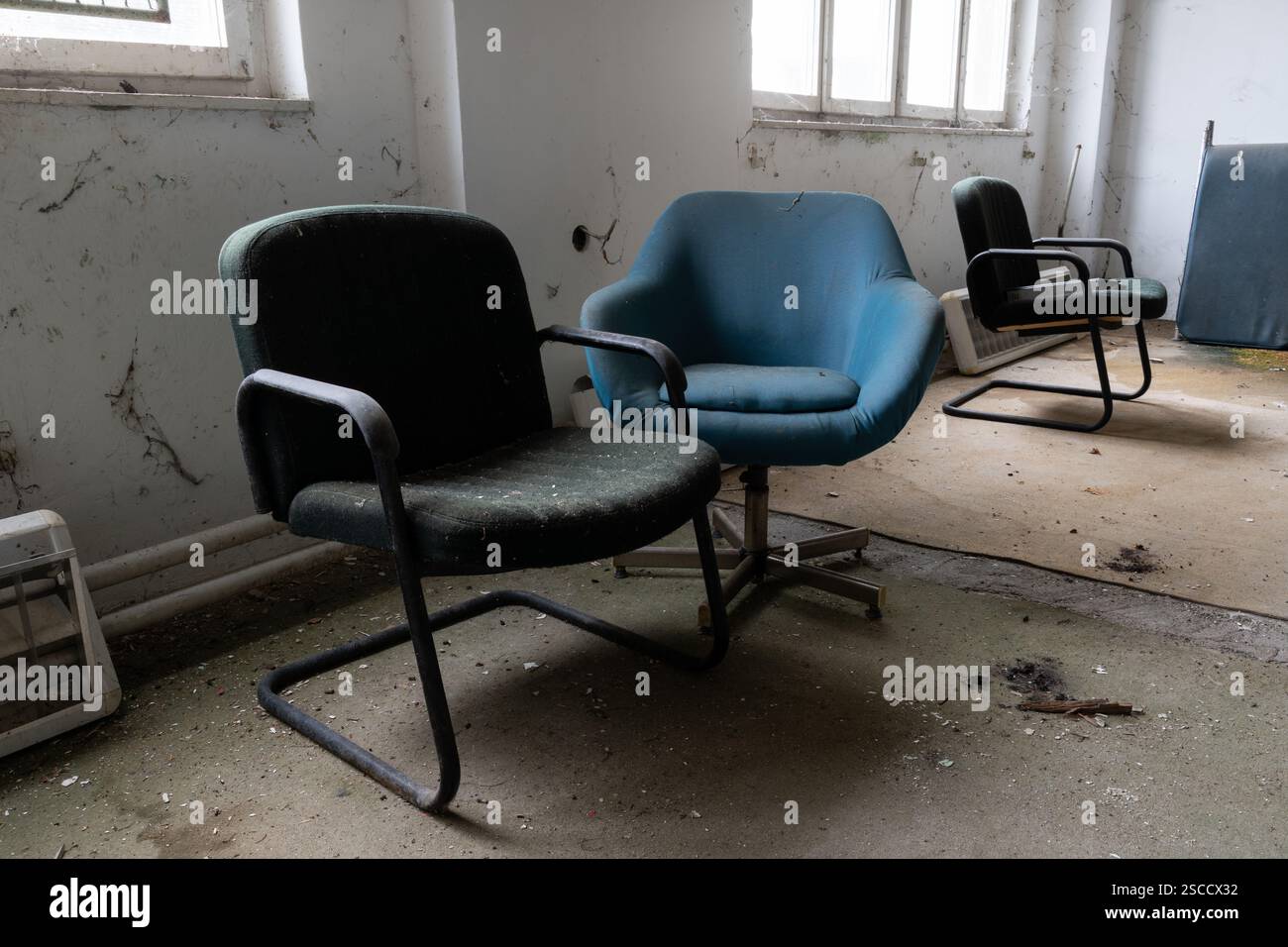 Dirty chairs in messy abandoned room next to window in natural light ...