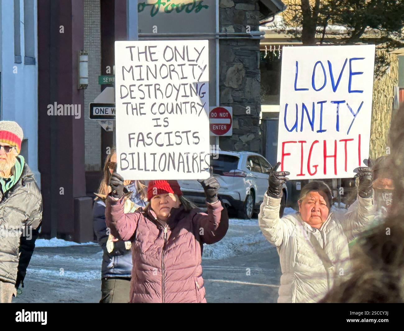 People hold signs as part of a protest against the Trump administration ...