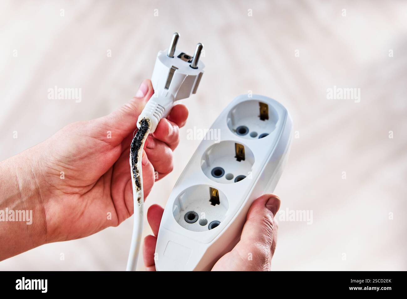 Burnt plug and power strip held in hands Stock Photo - Alamy