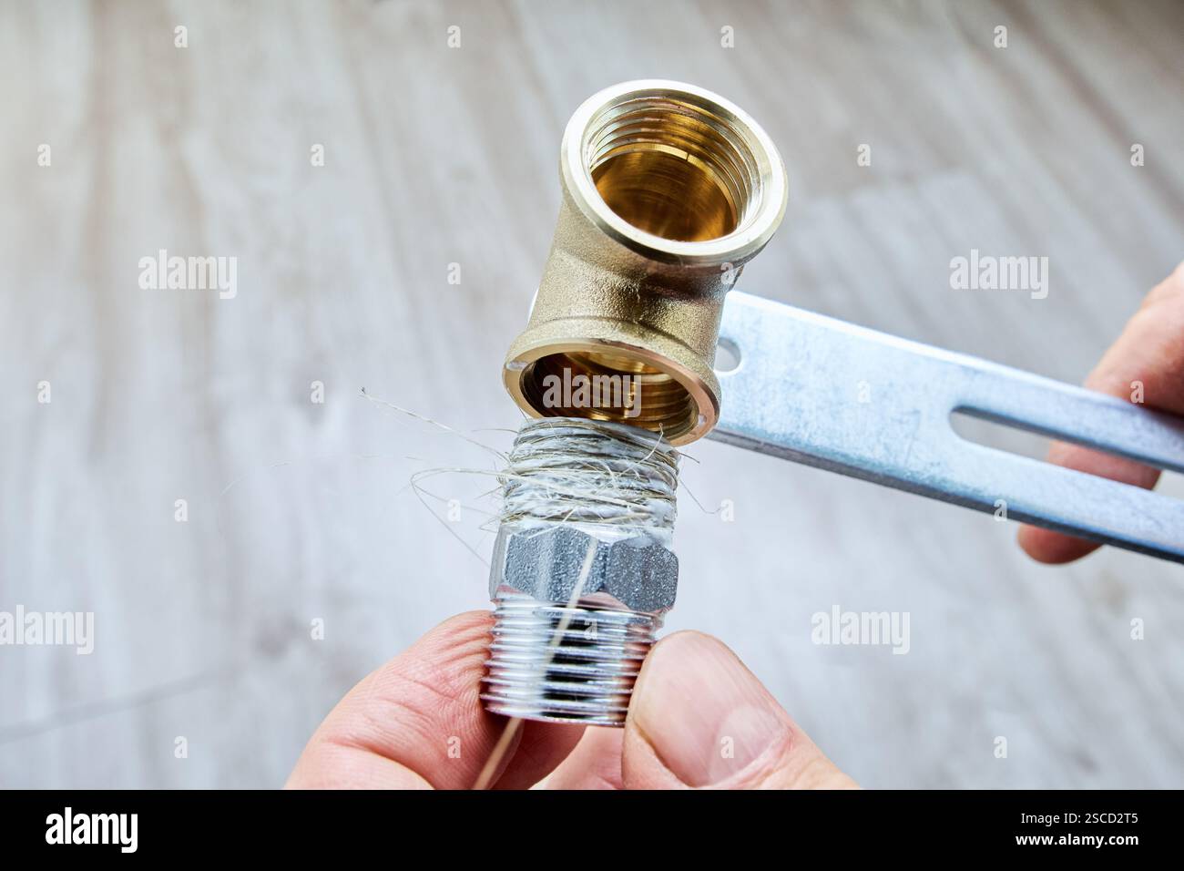 Plumbing flax and sealing paste are applied to male-threaded pipe ...