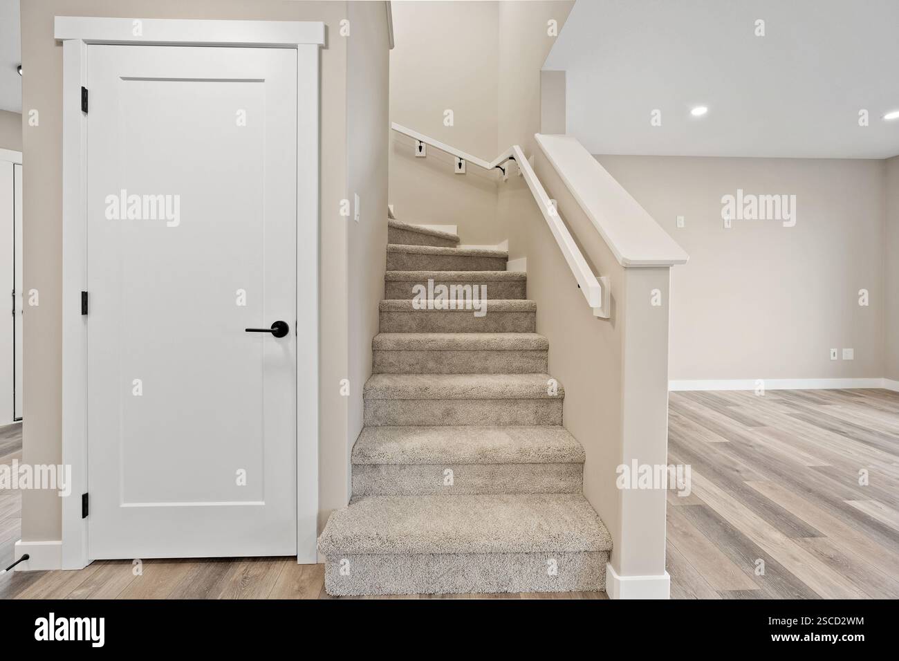 A white door with a black handle and a black knob. The door is next to ...