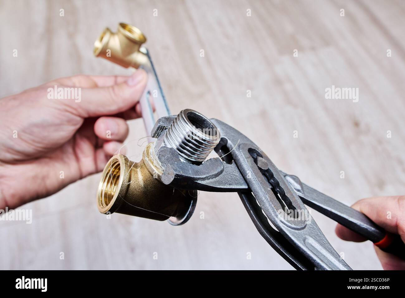 Wrench is tightening stainless steel threaded nipple wrapped in ...