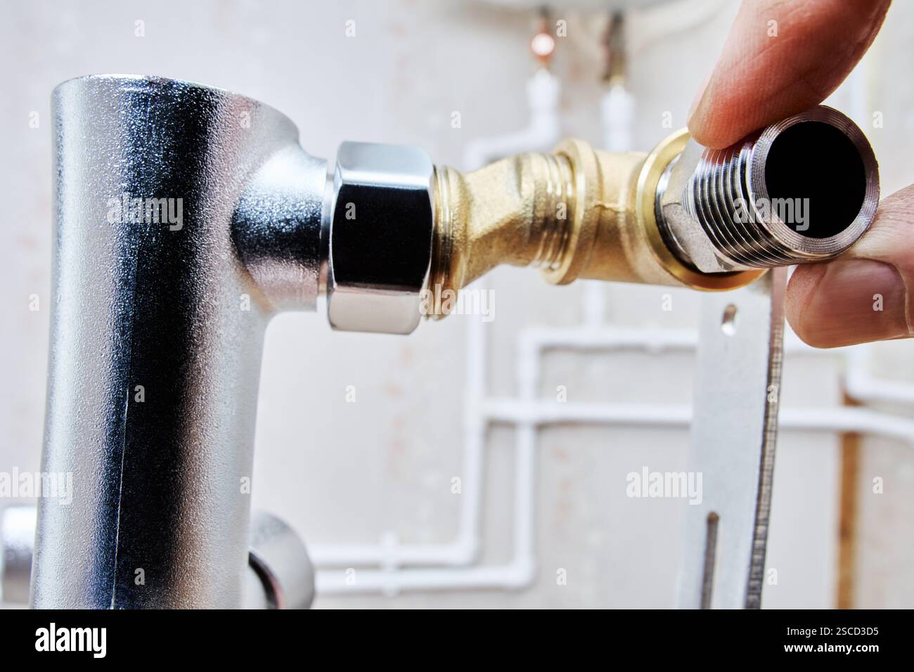 Plumber connects threaded reducer to brass fitting in plumbing system ...