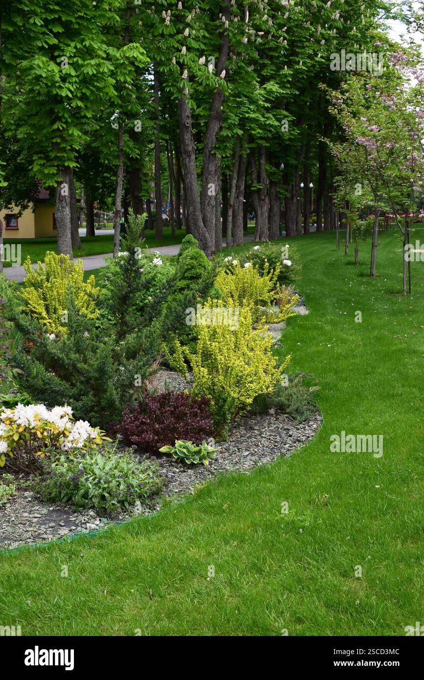 A well-maintained, lush green park area featuring a variety of shrubs ...