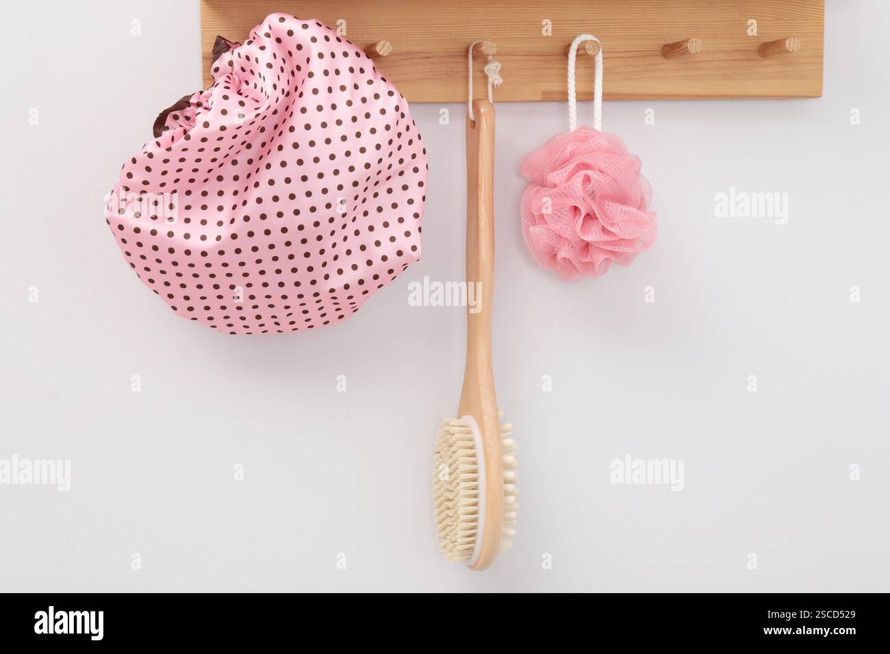 Shower cap, brush and mesh sponge on rack indoors Stock Photo - Alamy