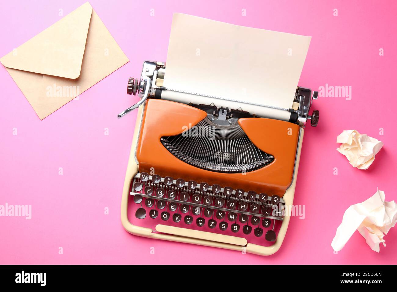 Vintage typewriter, crumpled paper and envelope on pink background ...