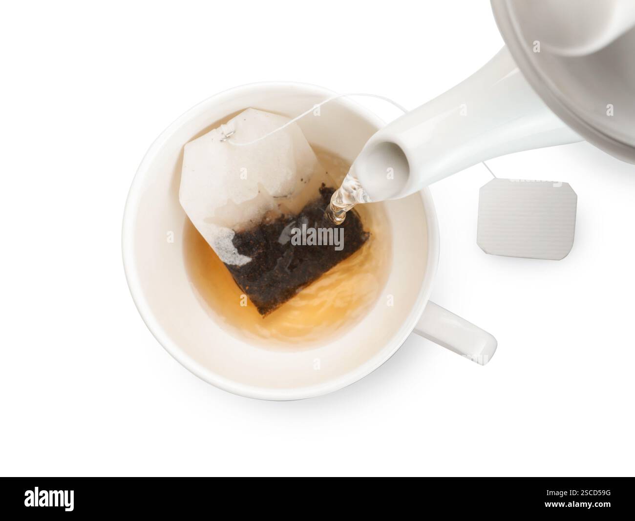 Pouring hot water into cup with tea bag on white background, top view ...