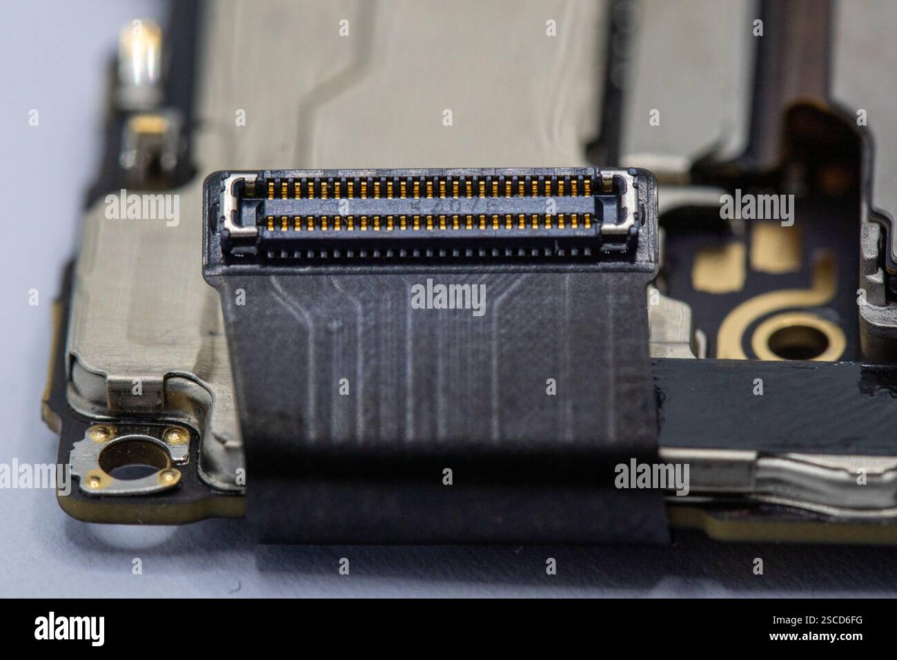 Close-up of a gold-plated connector with numerous pins, attached to a ...
