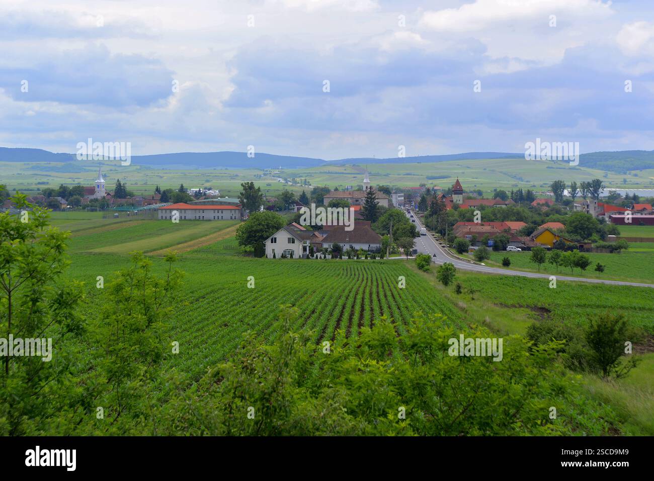 Acatari village amidst green fields and church towers on the European ...