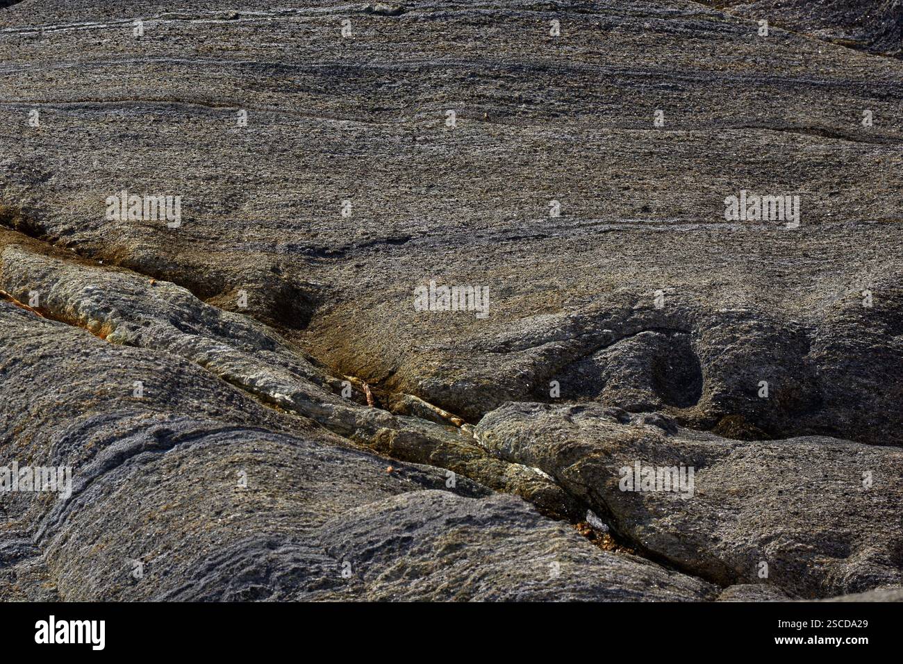 Rare dark stratified rock with oblique faulting Stock Photo - Alamy