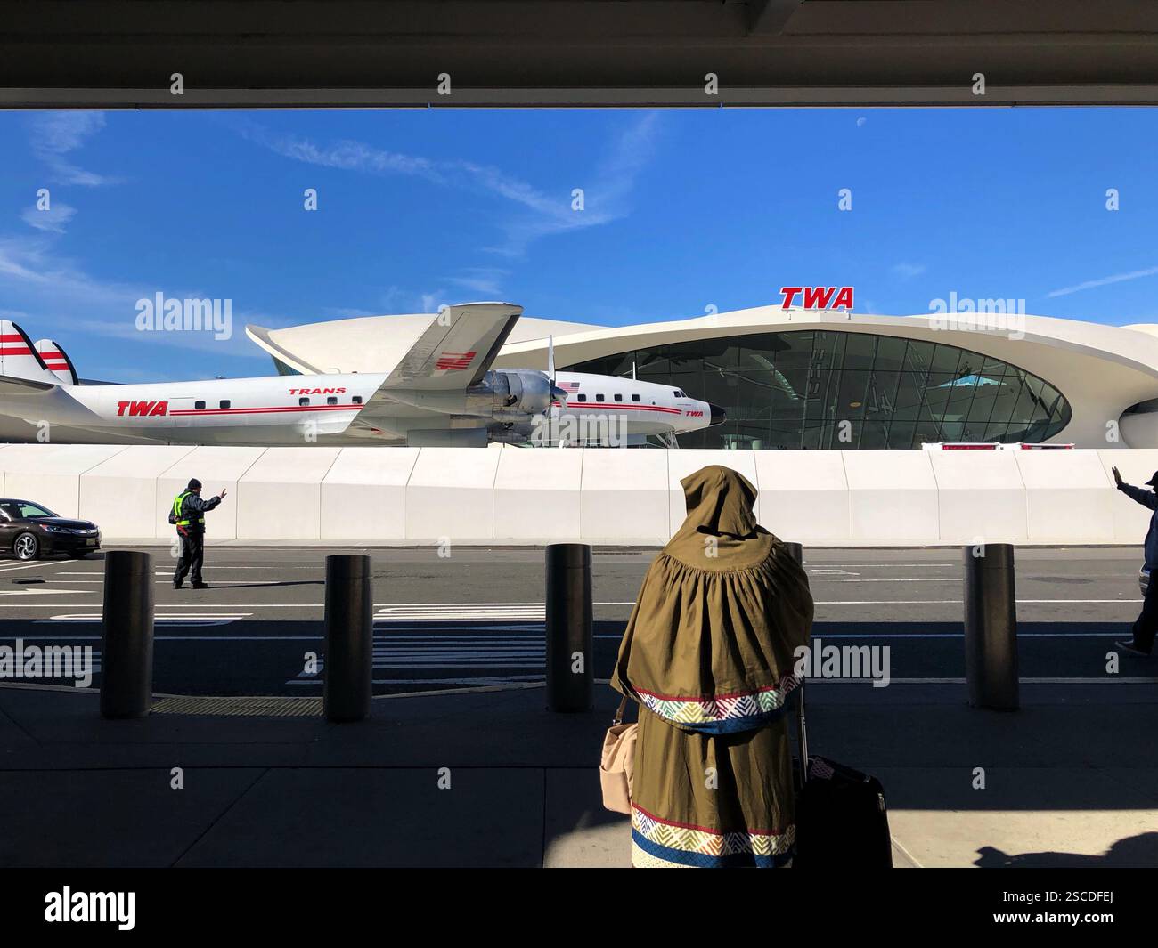 A traveler stands with luggage outside the TWA Hotel at John F. Kennedy ...