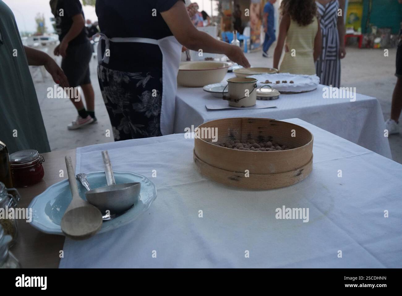 "Topia" on a table, balls of dough about to be cooked, food that women ...