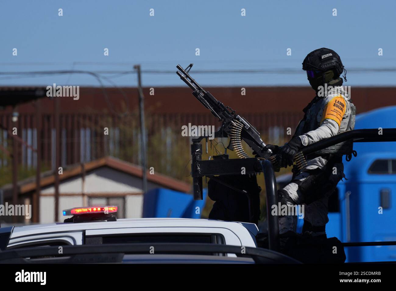 A Mexican National Guard stands watch next to the U.S. border wall in ...